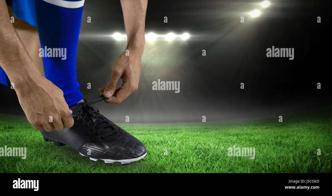 Digital composite of Low section of soccer player typing shoelace Stock ...