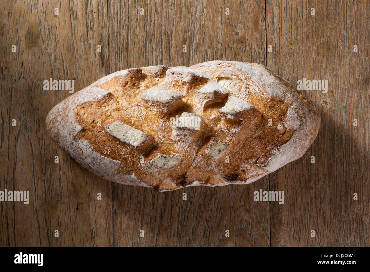 Above view of a rustic loaf of bread on an old wooden table Stock Photo ...