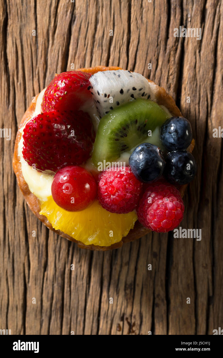 Fresh Fruit Flan sitting on a rustic wooden table Stock Photo - Alamy