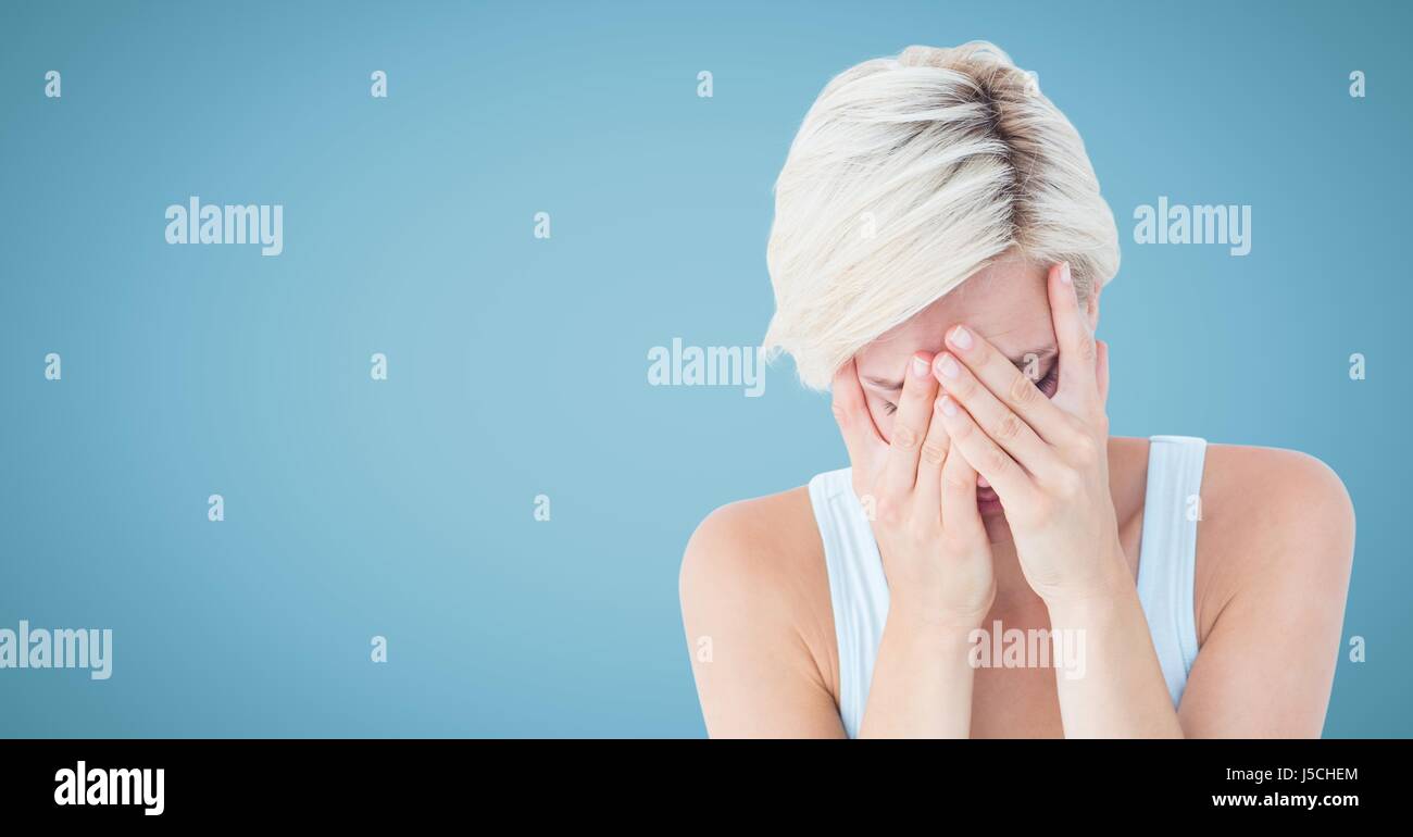 Digital composite of Woman crying in hands against blue background ...