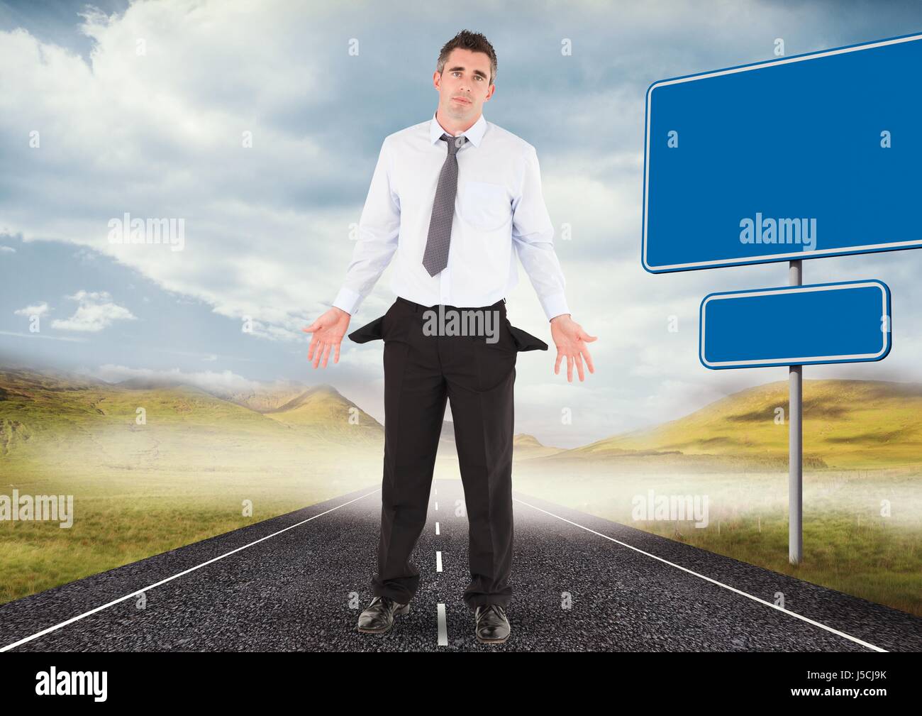 Digital composite of Businessman with empty pockets standing on road by ...