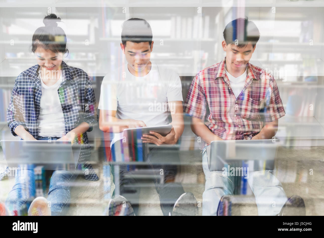 young asian people are using different gadgets and smiling, sitting ...