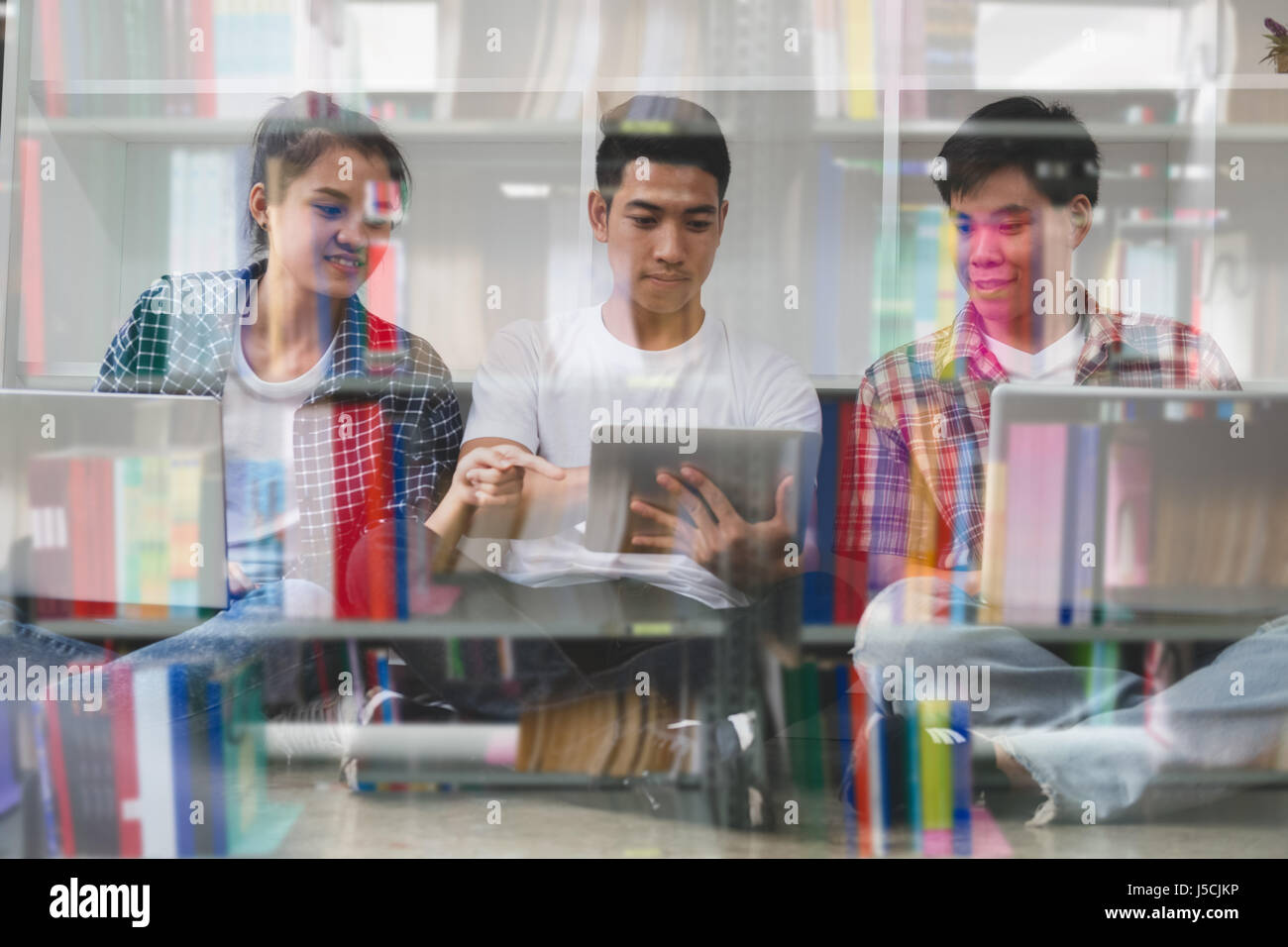 young asian people are using different gadgets and smiling, sitting ...