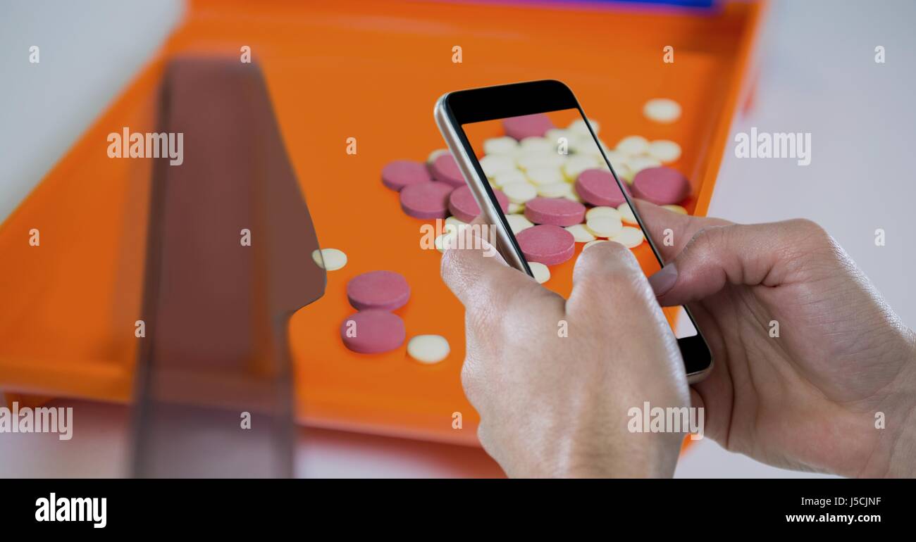 Digital composite of Hands photographing tablets through smart phone ...