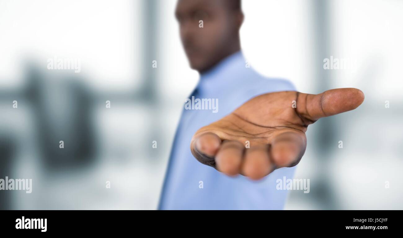 Digital composite of Businessman offering hand over blurred background ...