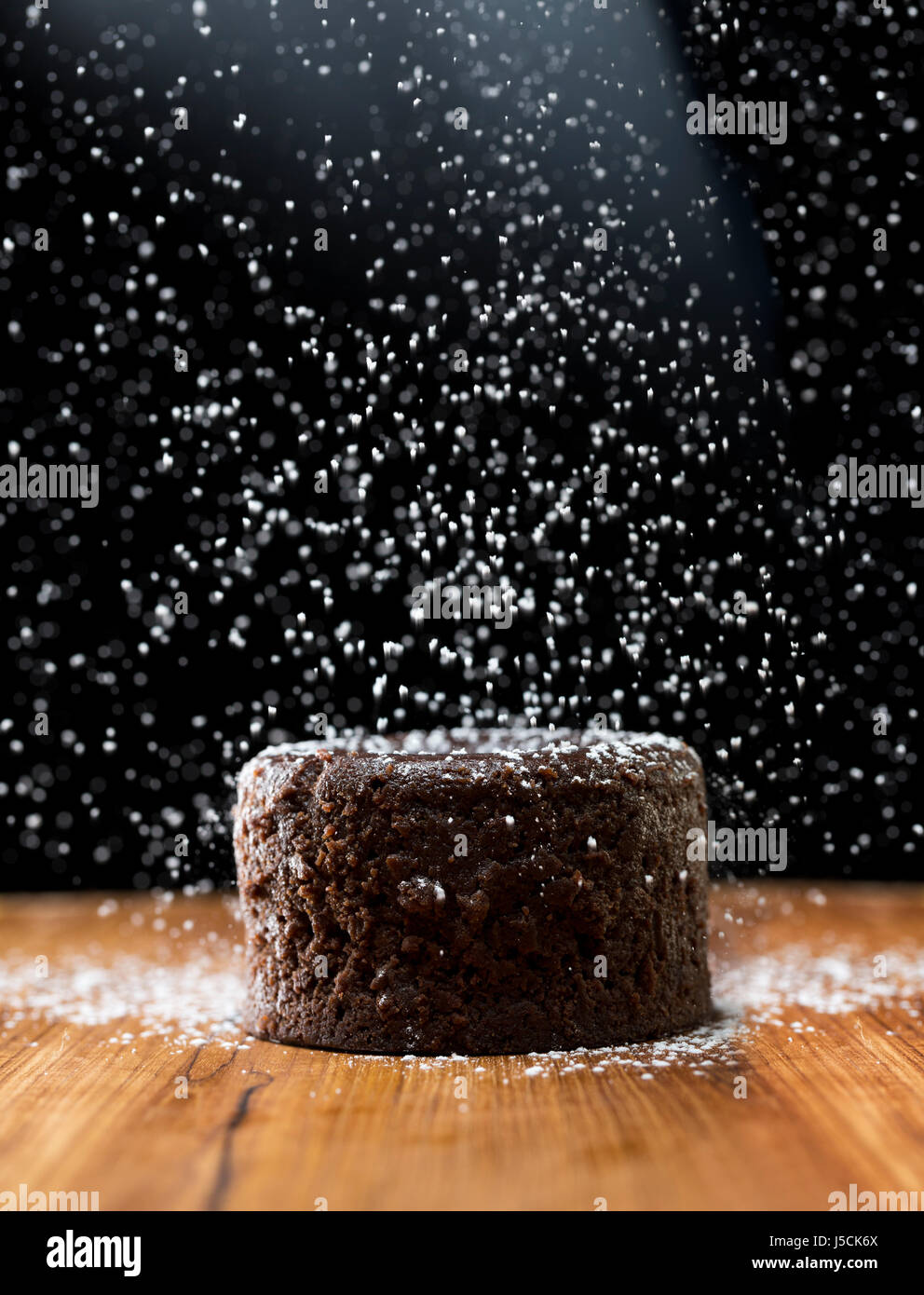 Icing sugar falling on Chocolate Lava Cake. Chocolate pudding sitting ...