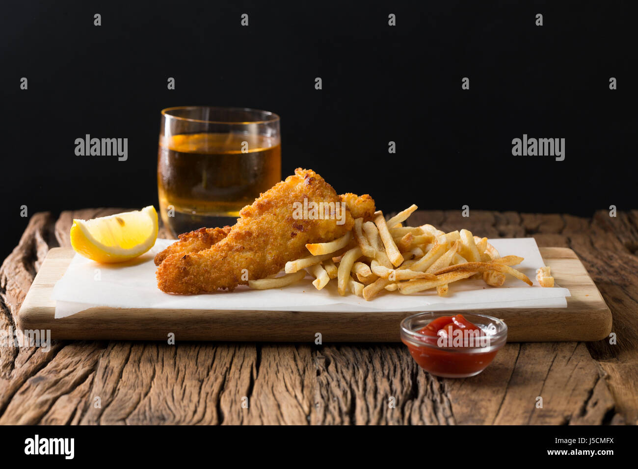 Freshly cooked fish and chips on a rustic wooden background. Gastropub ...