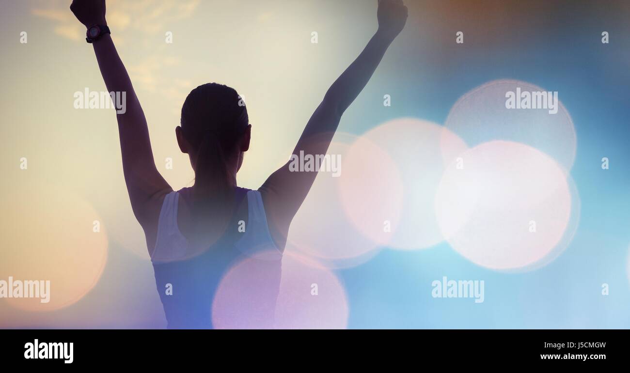 Digital composite of Rear view of fit woman with arms raised by with ...