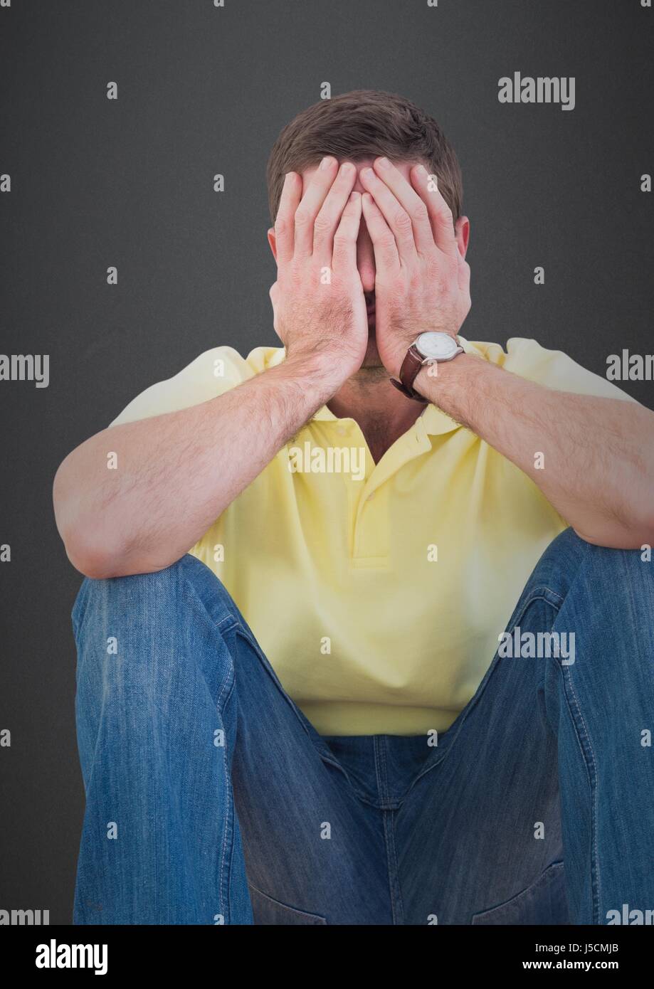 Digital composite of Man sitting and crying against grey wall Stock ...