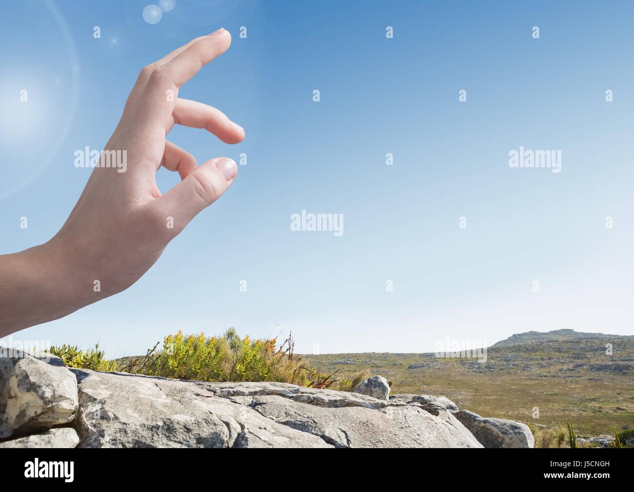 Digital composite of Hand Touching sky in landscape Stock Photo - Alamy