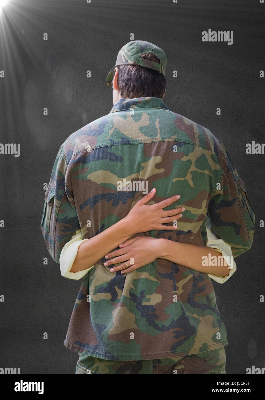 Digital composite of Back of soldier hugging against grey wall with ...
