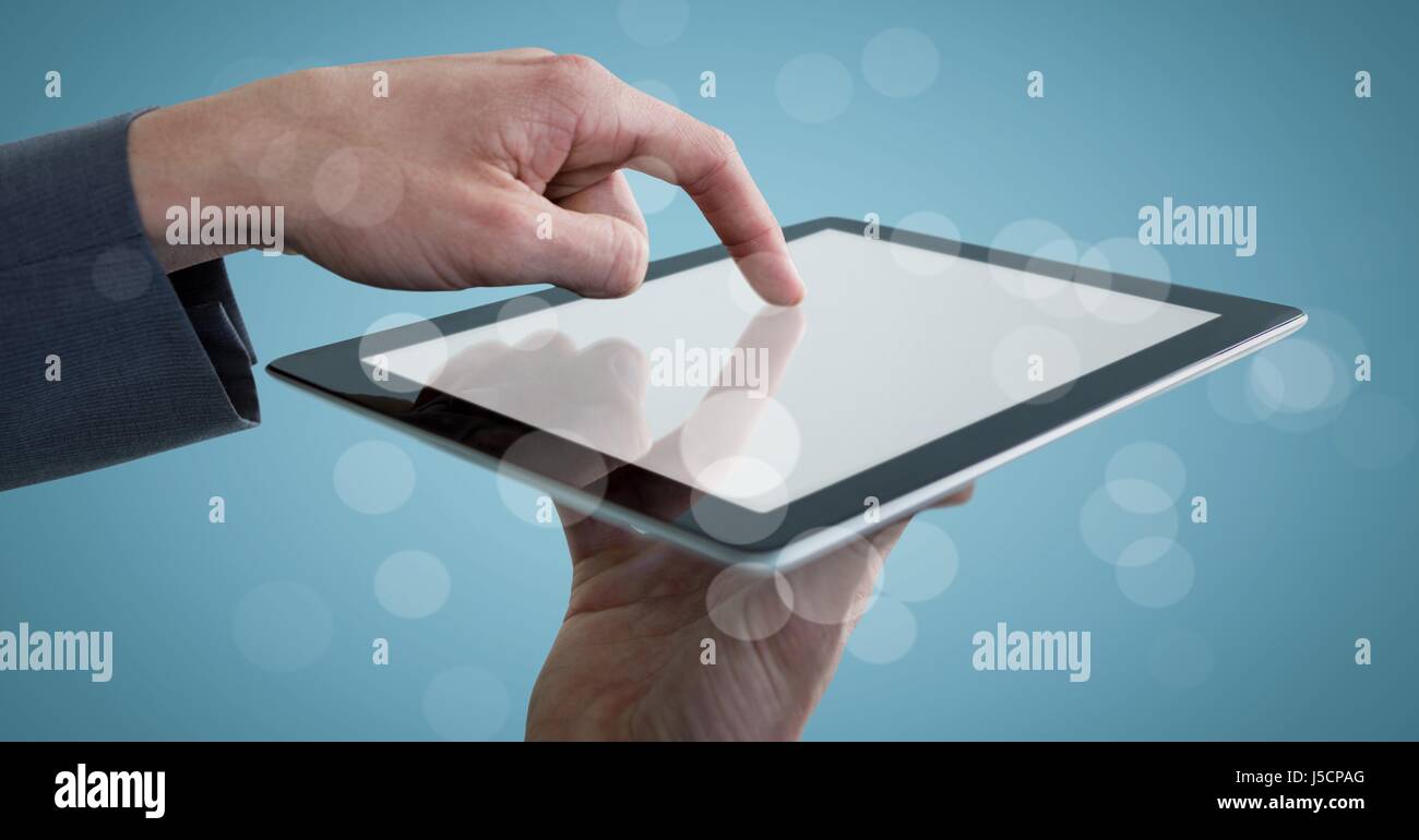 Digital composite of Hands touching tablet behind bokeh against blue ...