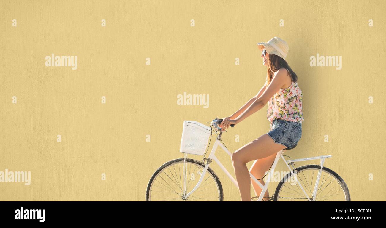 Digital composite of Side view of woman riding cycle over beige ...