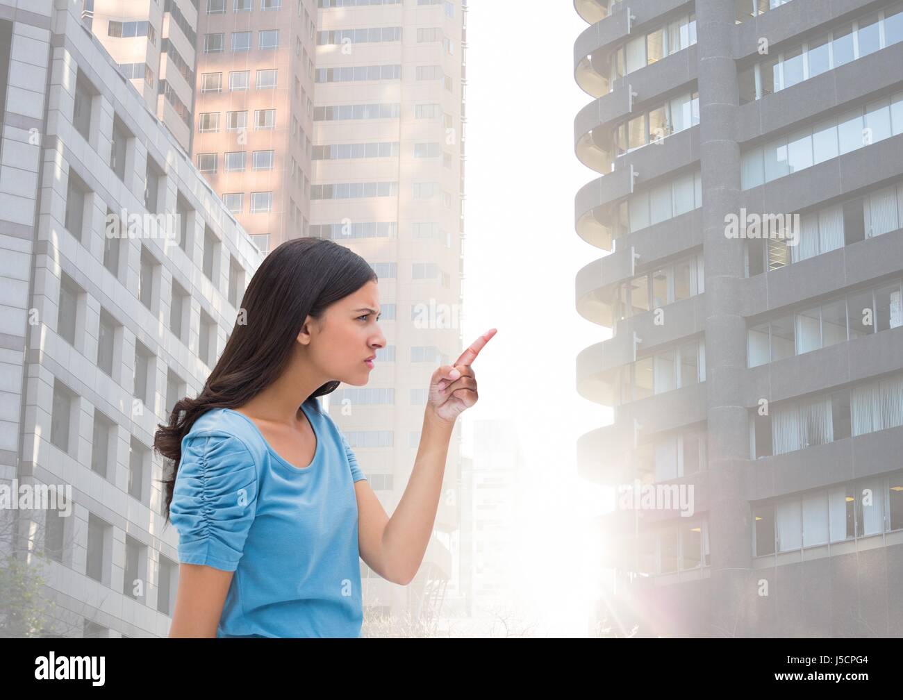 Digital composite of Woman pointing at tall buildings flare Stock Photo ...