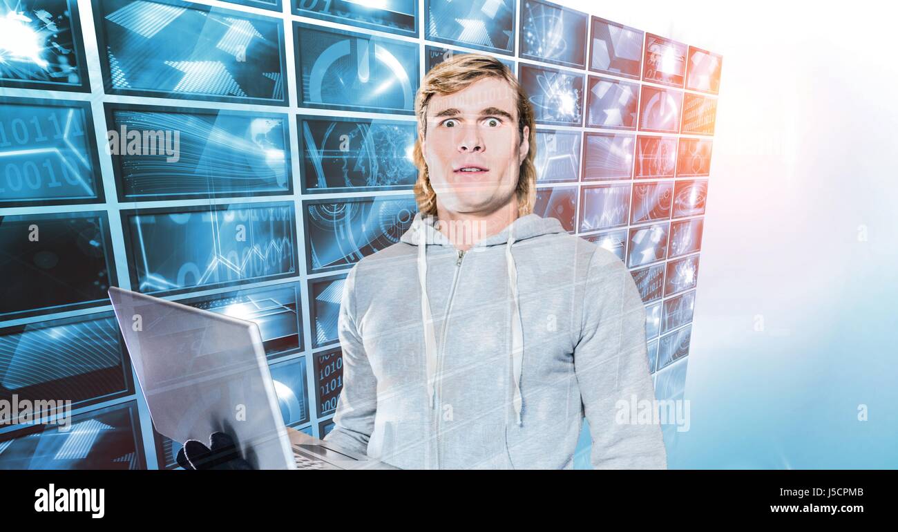 Digital composite of Shocked hacker holding laptop by screens Stock ...