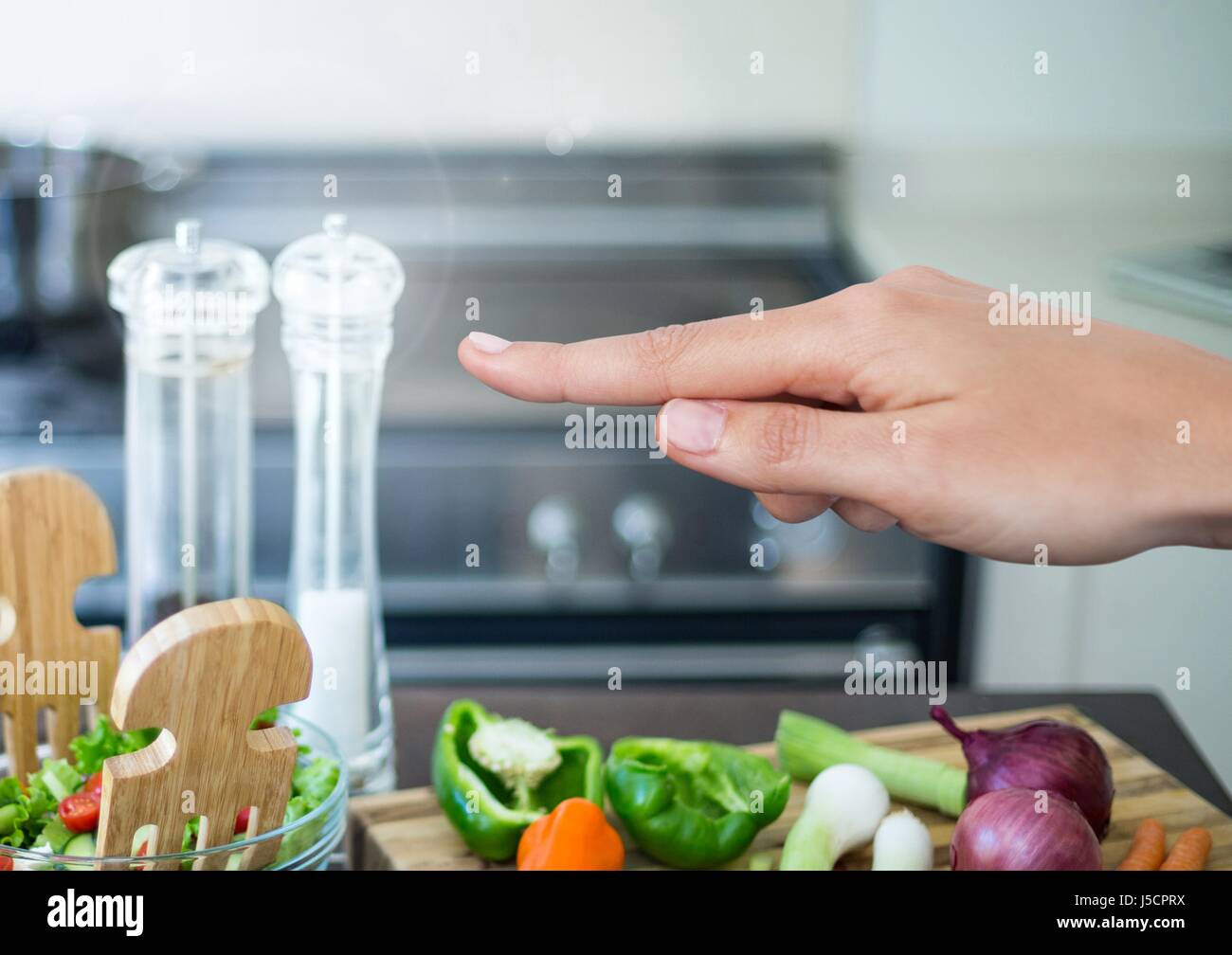 Digital composite of Hand touching air with cooking objects in kitchen ...
