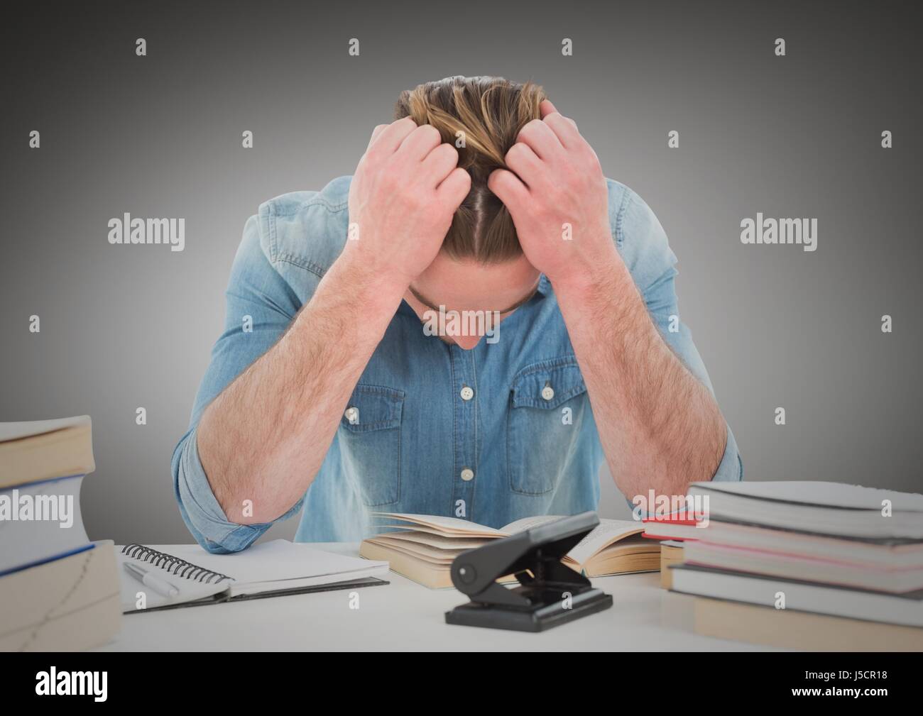 Digital composite of Man stressed at desk against grey background Stock ...