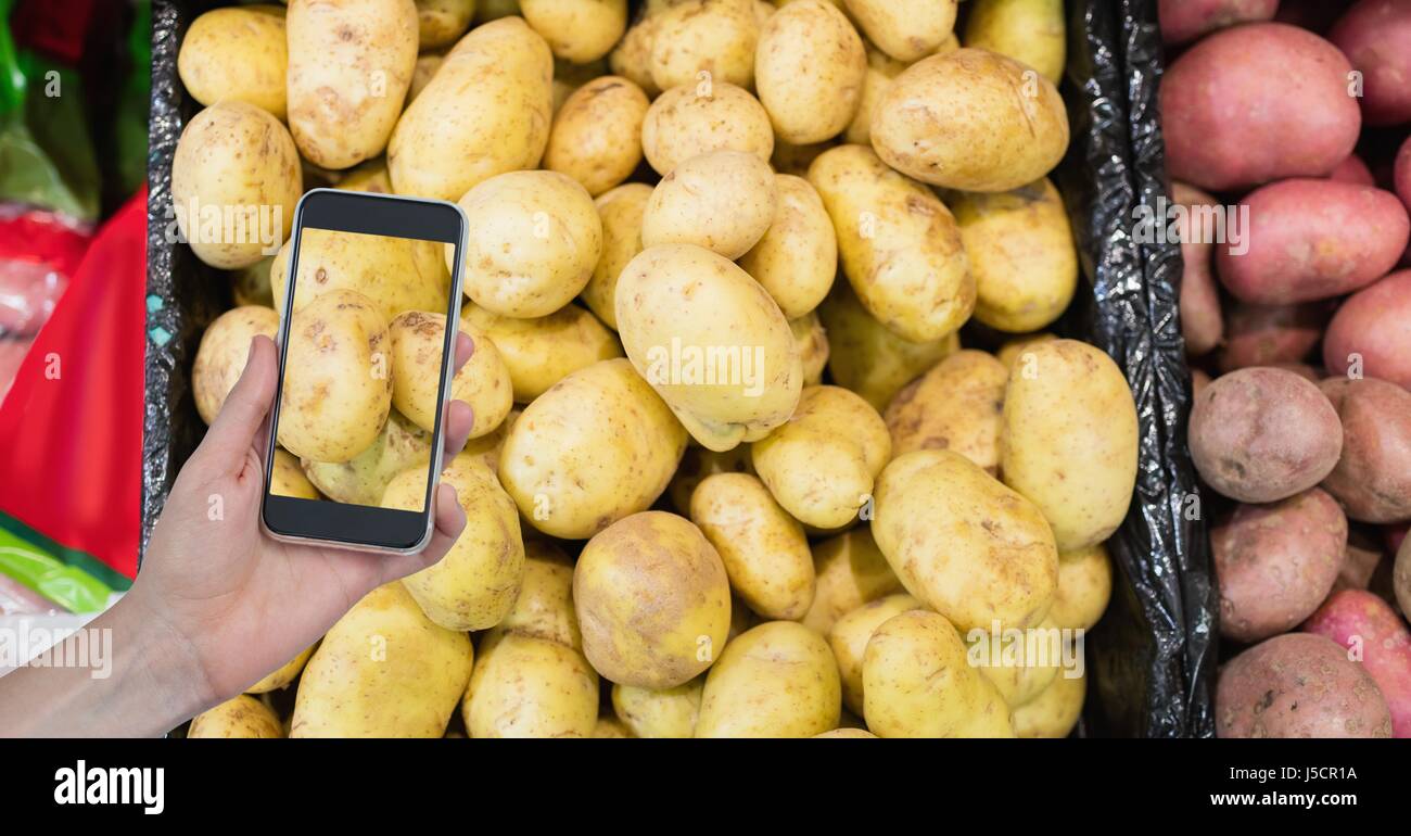 Digital composite of Hand taking picture of potatoes with mobile phone ...