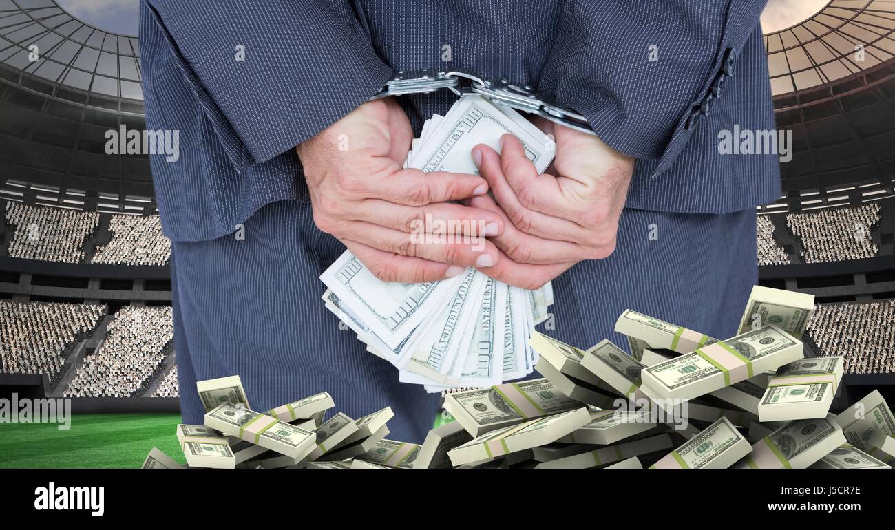 Digital composite of Hands with handcuffs and money at football stadium ...