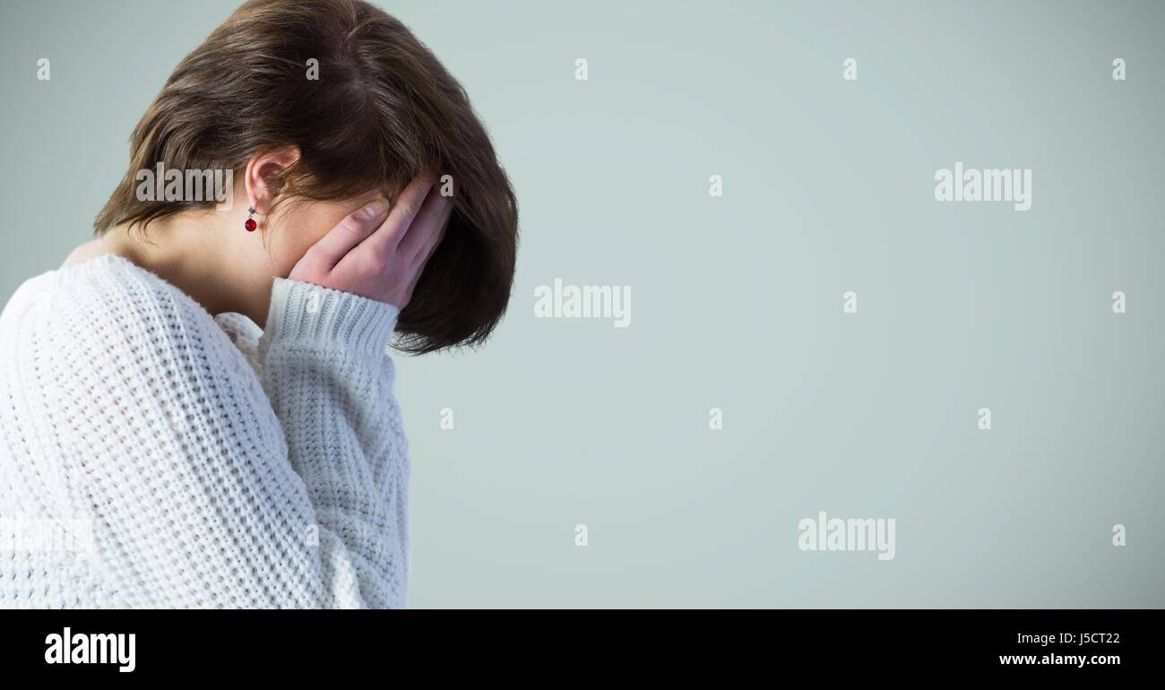 Digital composite of Woman profile with hands over face against light ...