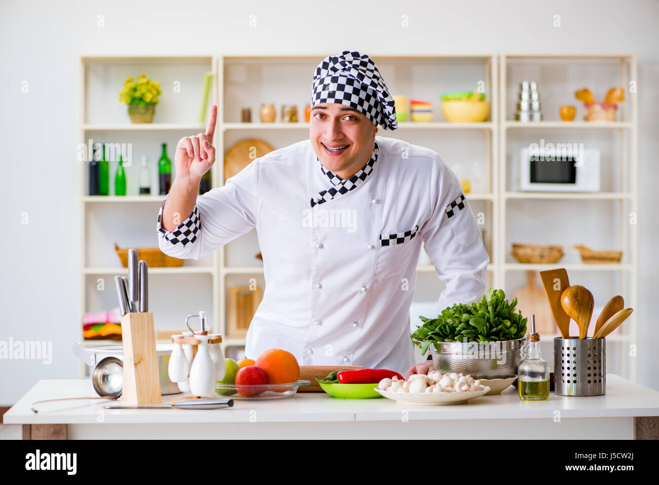 Young male cook working in the kitchen Stock Photo - Alamy