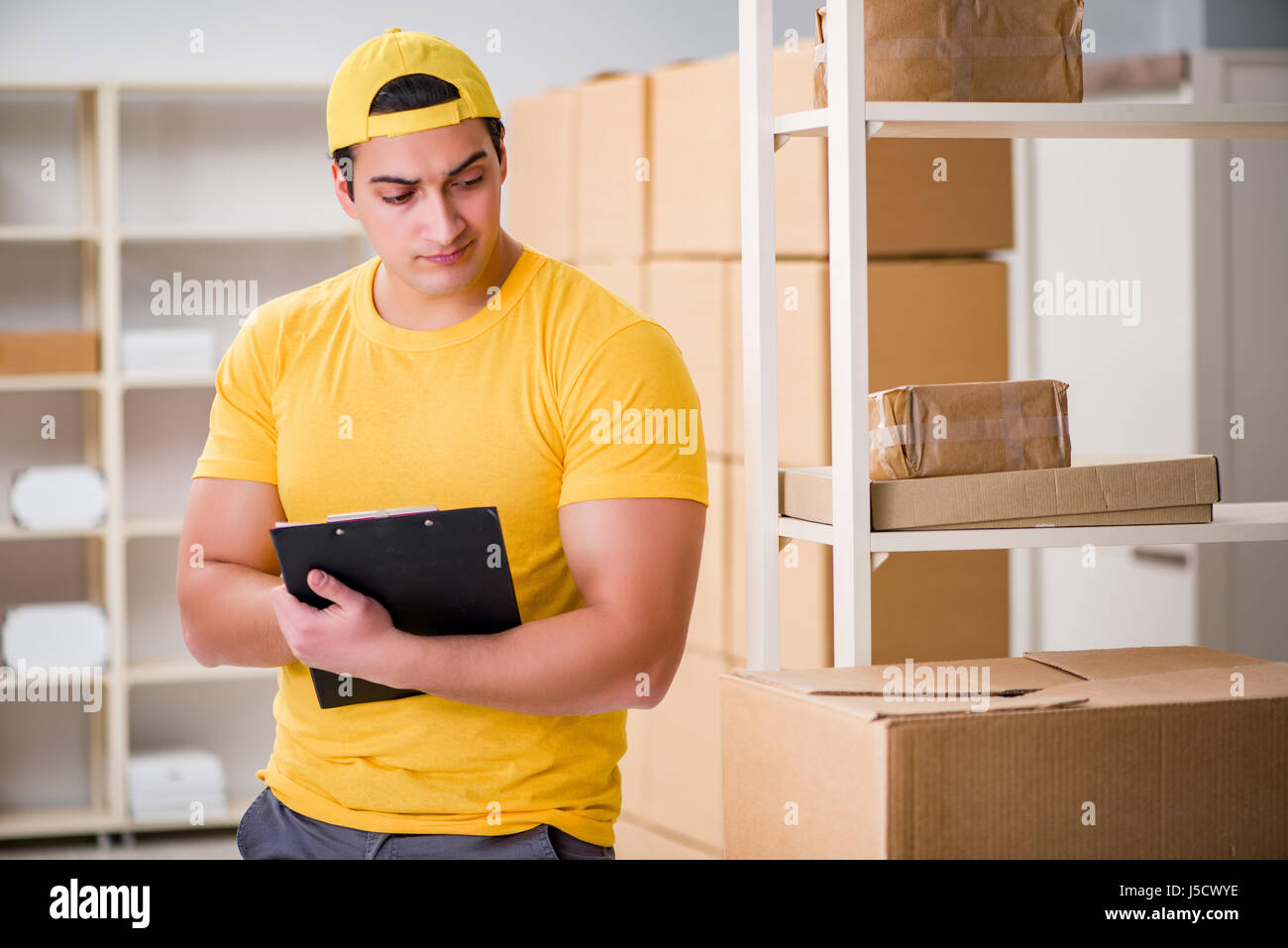 Man working in postal parcel delivery service office Stock Photo - Alamy