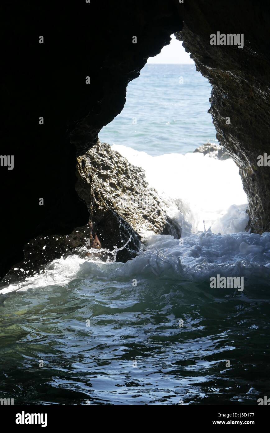 Sea water flowing in through a cave-like rock formation Water flows in ...