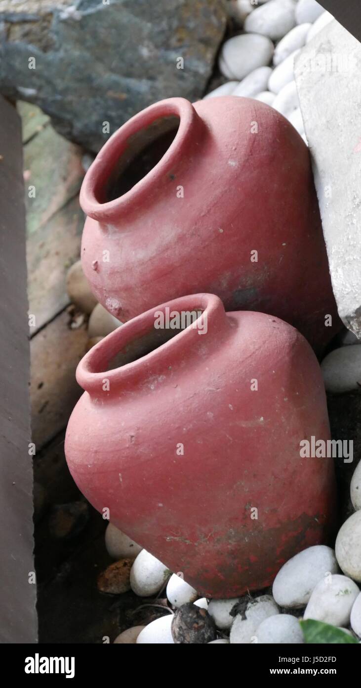 two earthen jars with white stones Two big red earthen jars on the ...