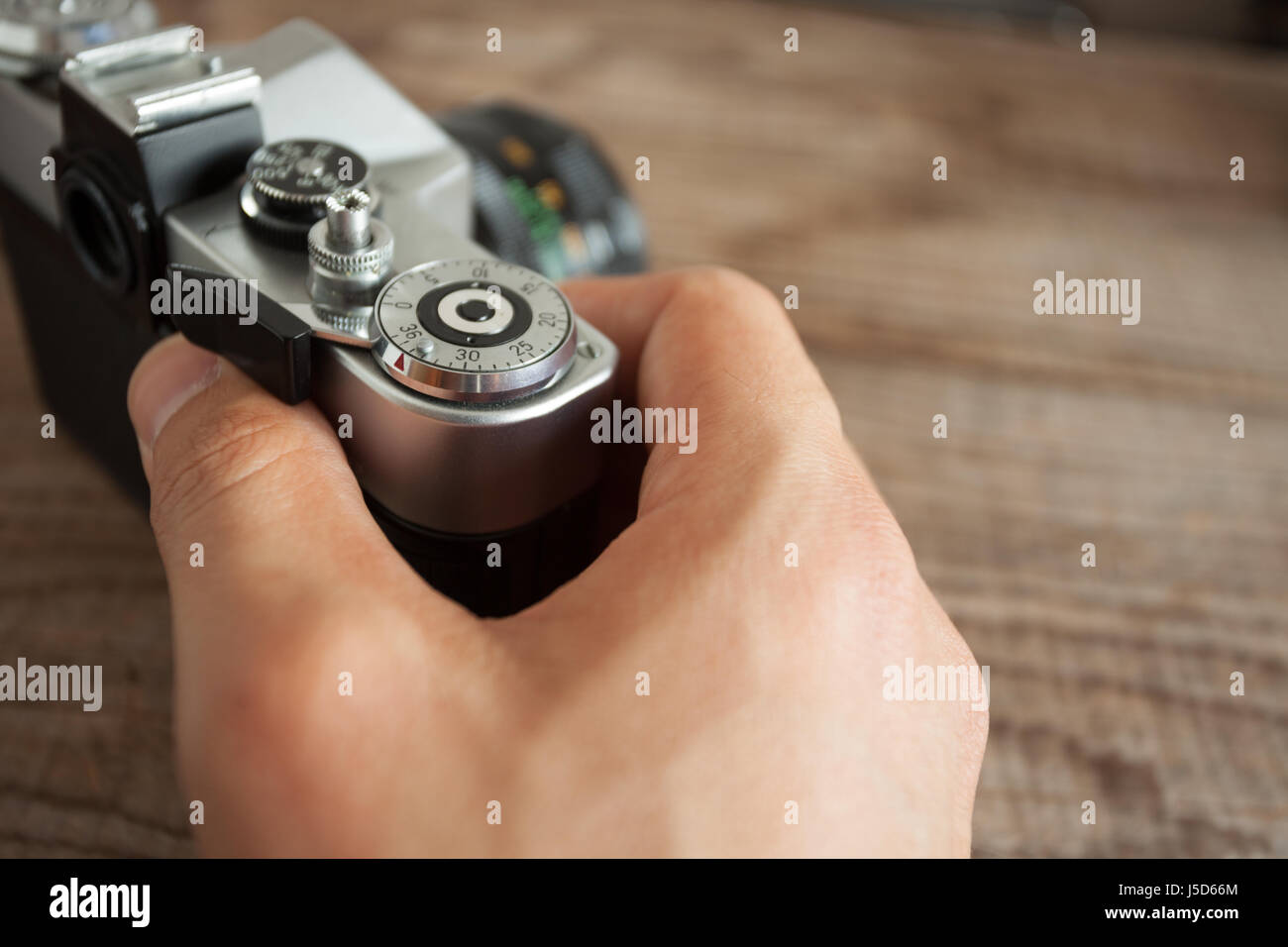 photographer keep a vintage film camera, lying over a dated wooden ...