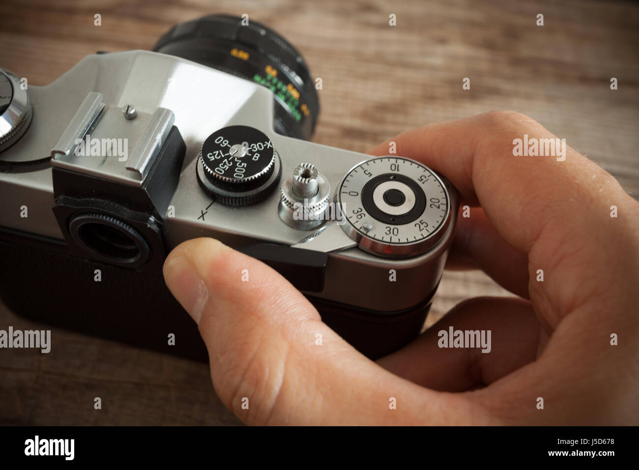 photographer keep a vintage film camera, lying over a dated wooden ...