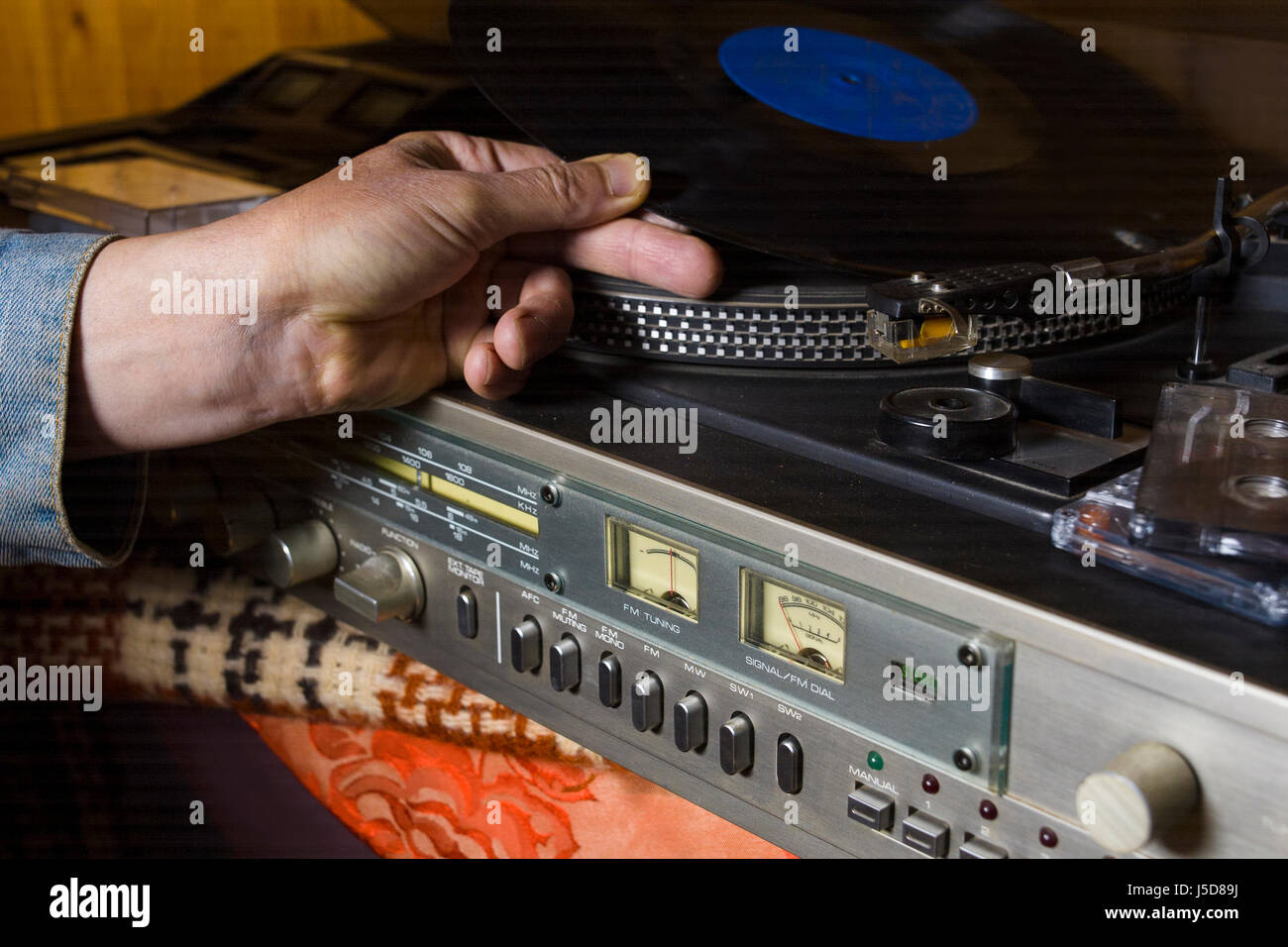A DJ hand with vinyl record, closeup indoor shot, concept of a prty in ...