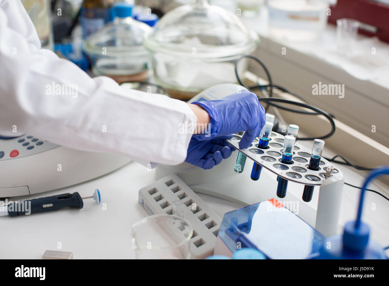 Young female scientist works in modern chemistry/biology lab (shallow ...