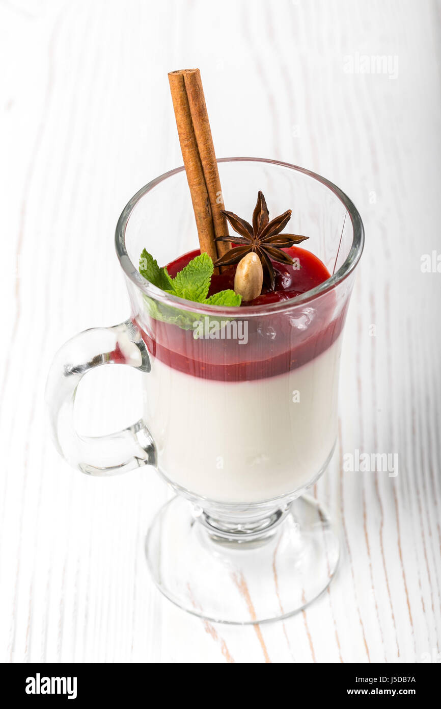 Panakota in a glass on a wooden background. Panakota with leaves of ...