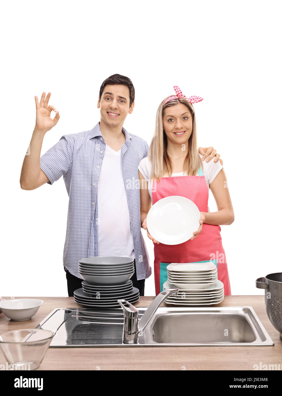 Young couple with stacks of clean plates making an ok sign isolated on ...
