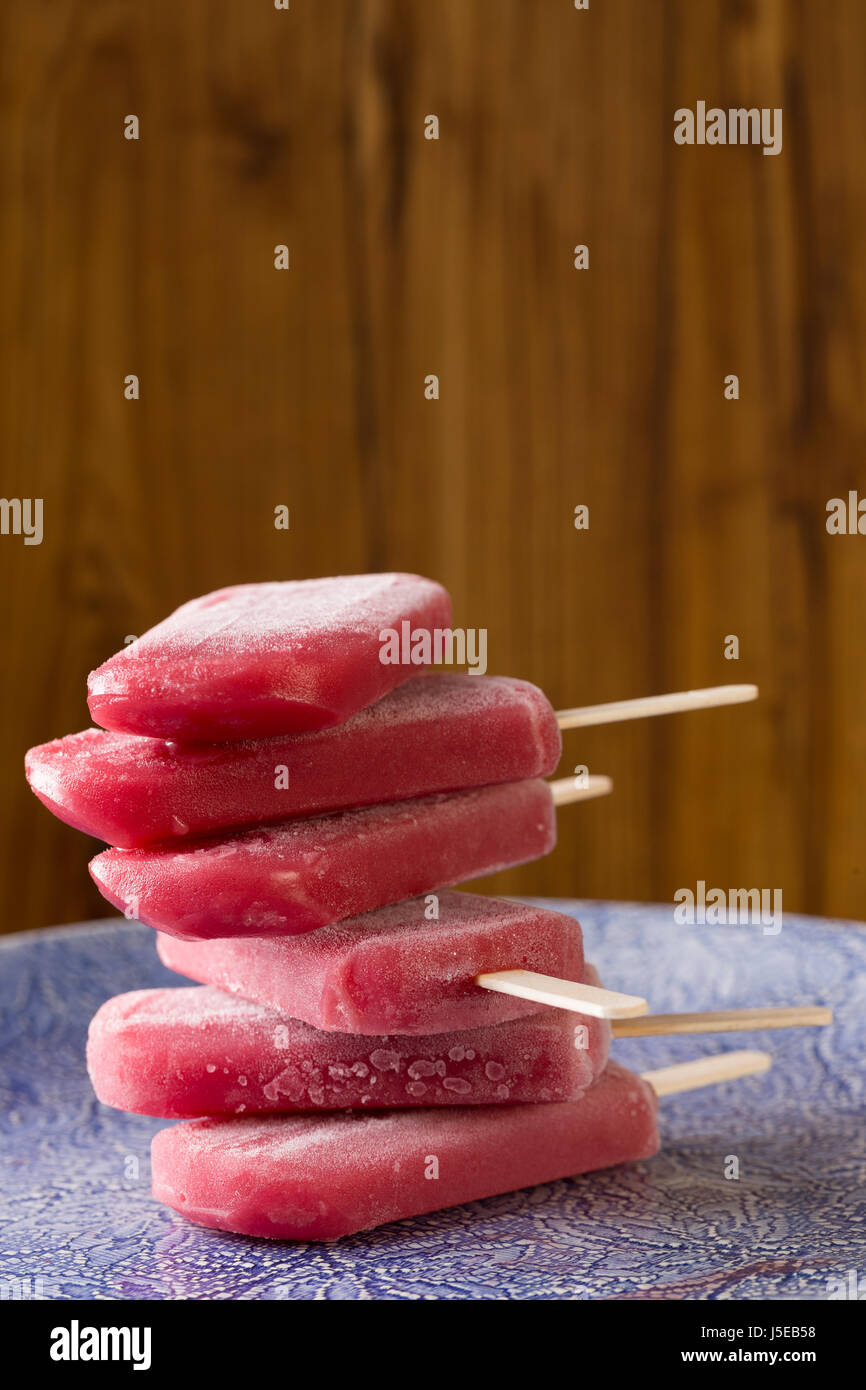 Homemade Raspberry and vanilla ice pops on a rustic wood background ...