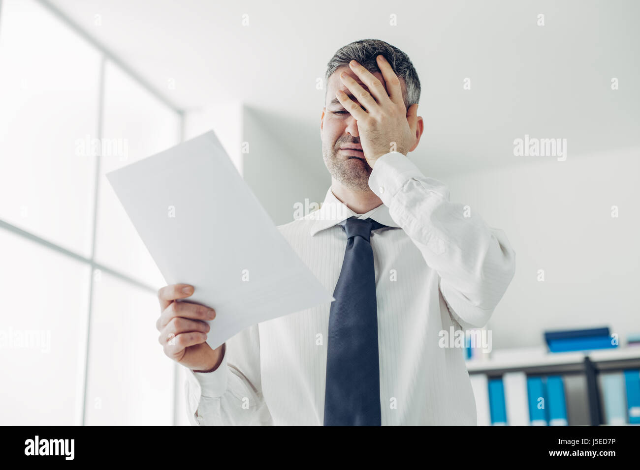 Desperate office worker receiving a dismissal letter from his boss ...