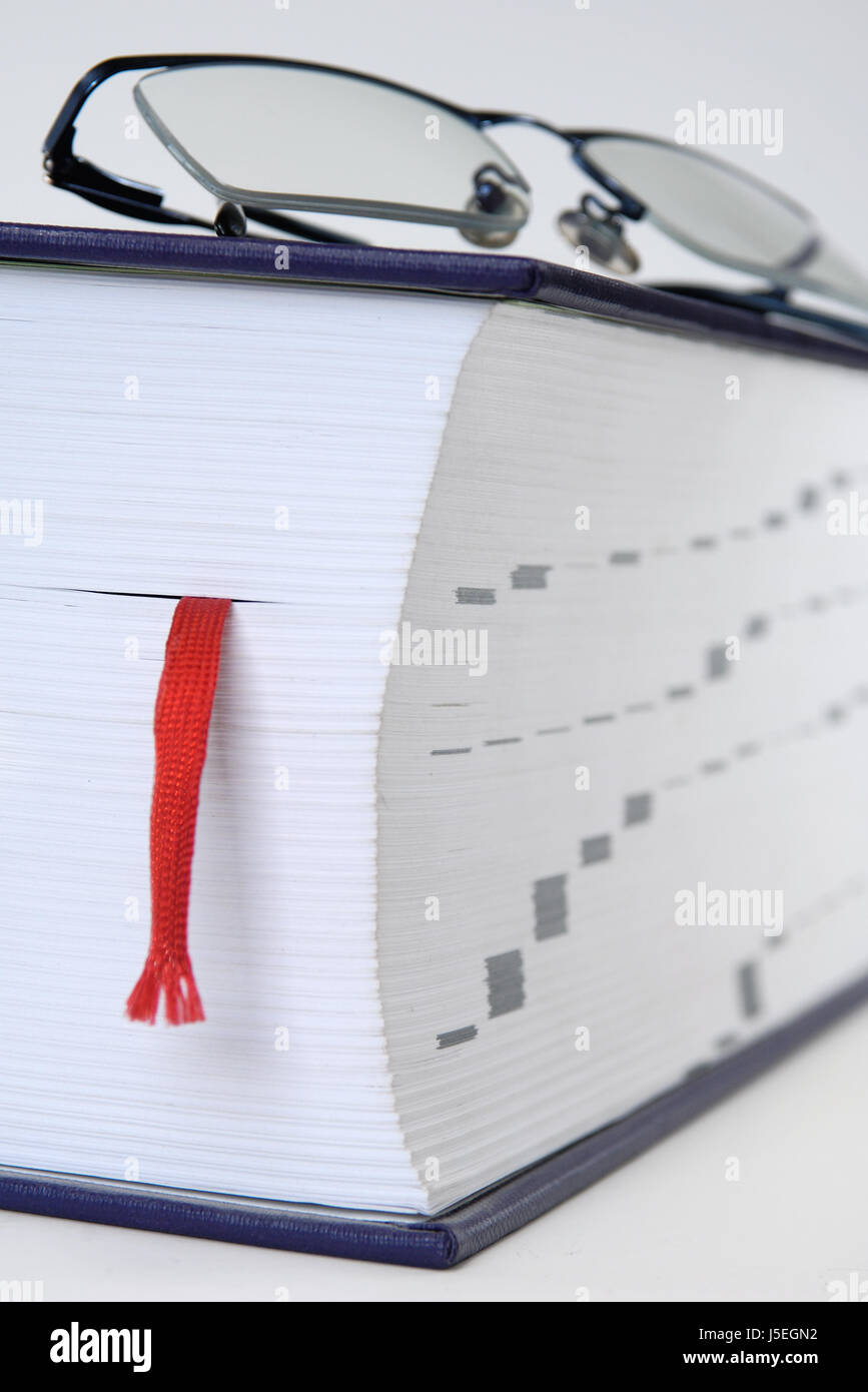very thick book with reading glasses Stock Photo - Alamy