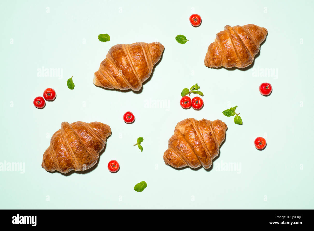Breakfast with fresh tasty croissants on green background Stock Photo ...