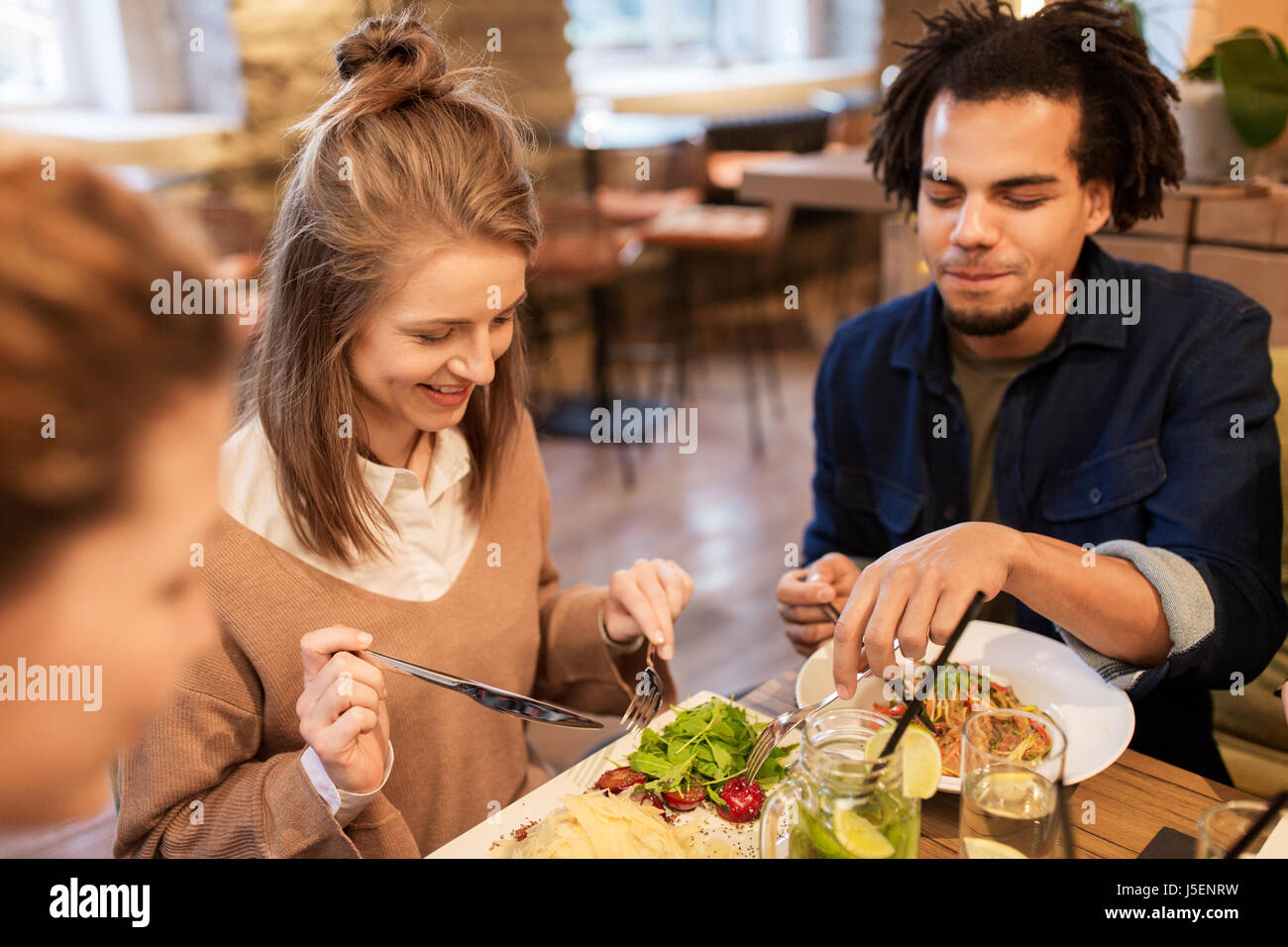 happy friends eating and drinking at restaurant Stock Photo - Alamy