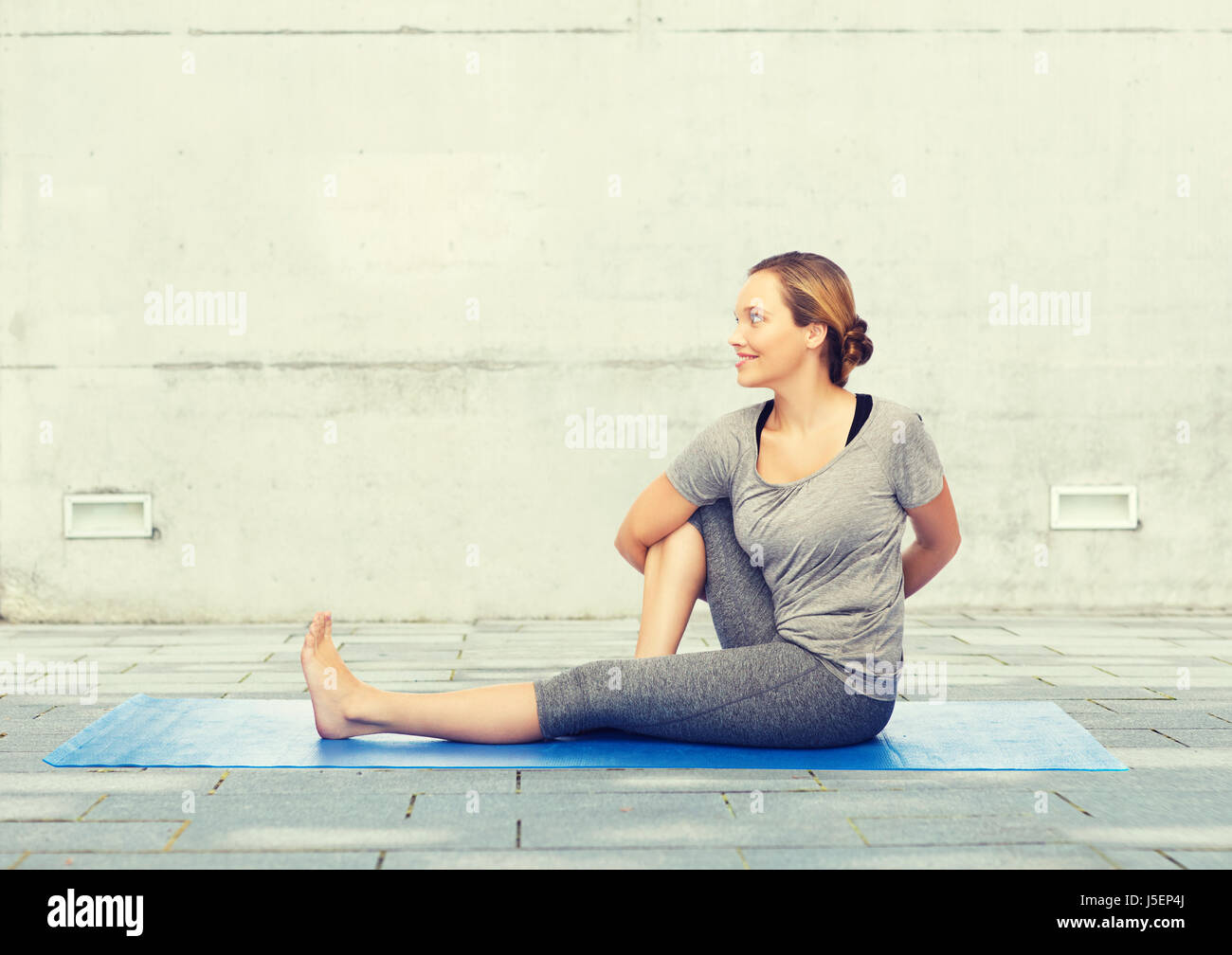 woman making yoga in twist pose on mat Stock Photo - Alamy