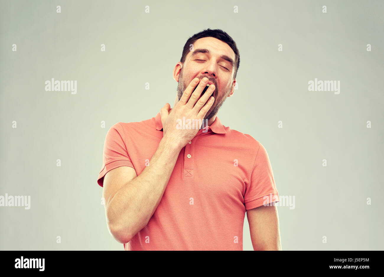yawning man over gray background Stock Photo - Alamy