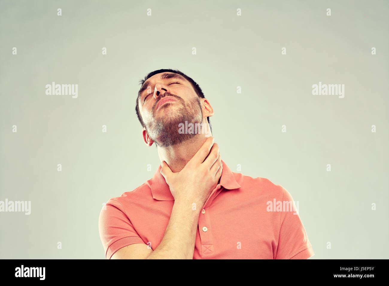 man touching neck and suffering from throat pain Stock Photo - Alamy