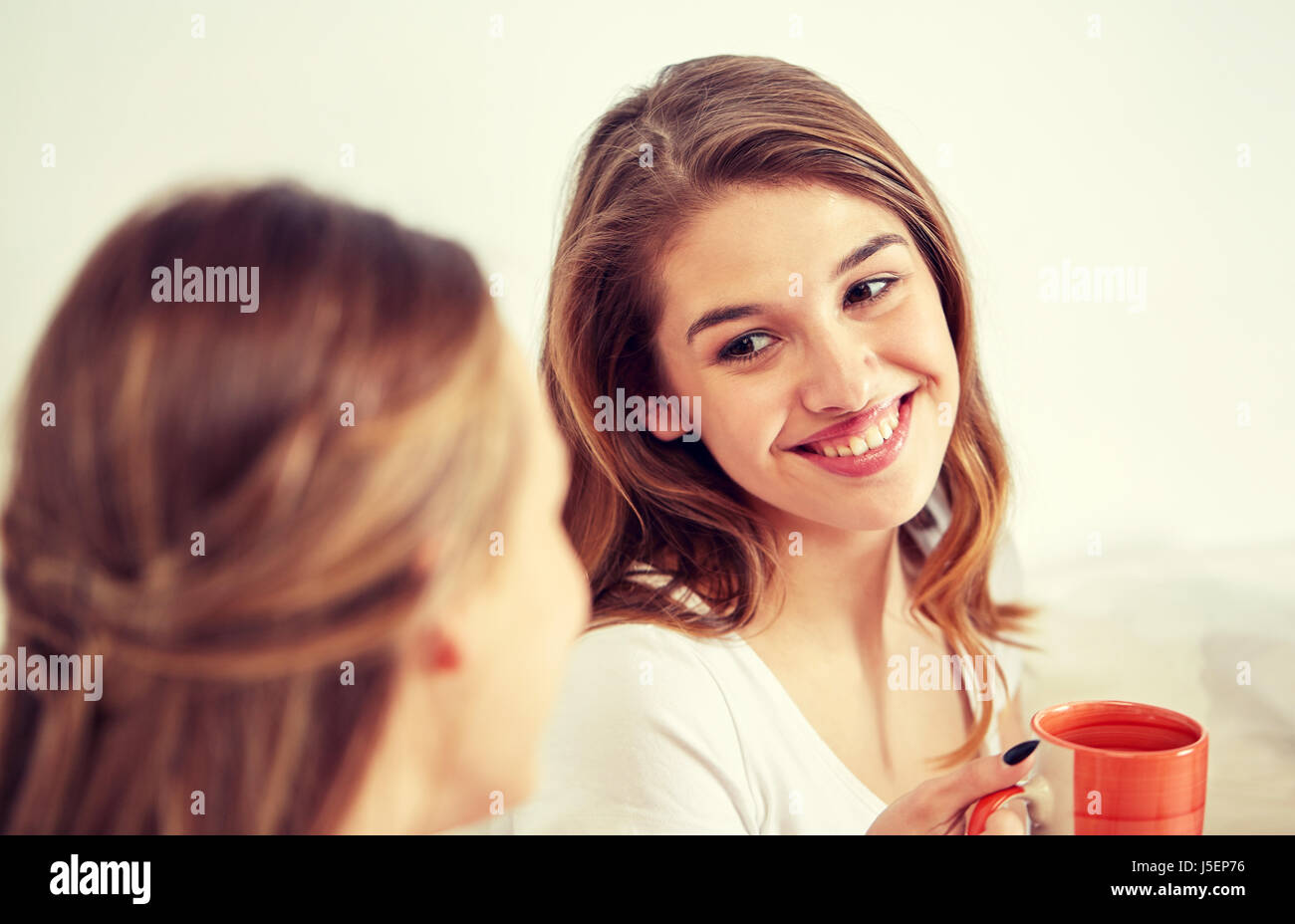 happy young women drinking tea with sweets at home Stock Photo - Alamy