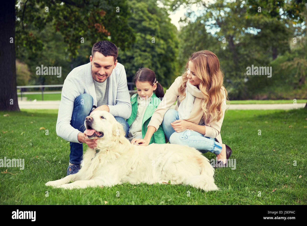 happy family with labrador retriever dog in park Stock Photo - Alamy