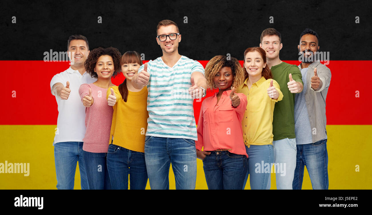 happy people showing thumbs up over german flag Stock Photo - Alamy