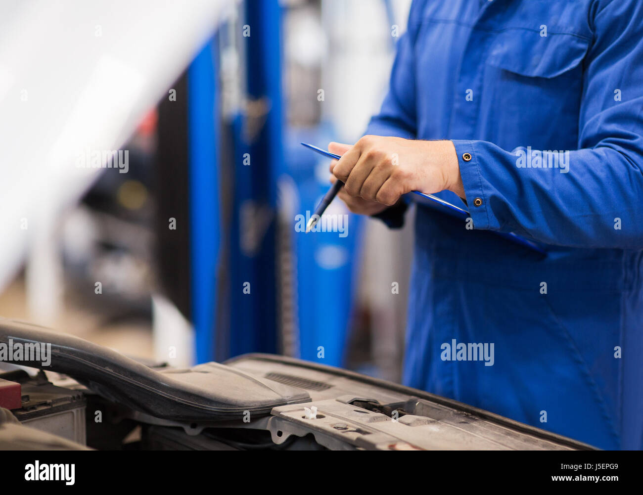 auto mechanic man with clipboard at car workshop Stock Photo - Alamy