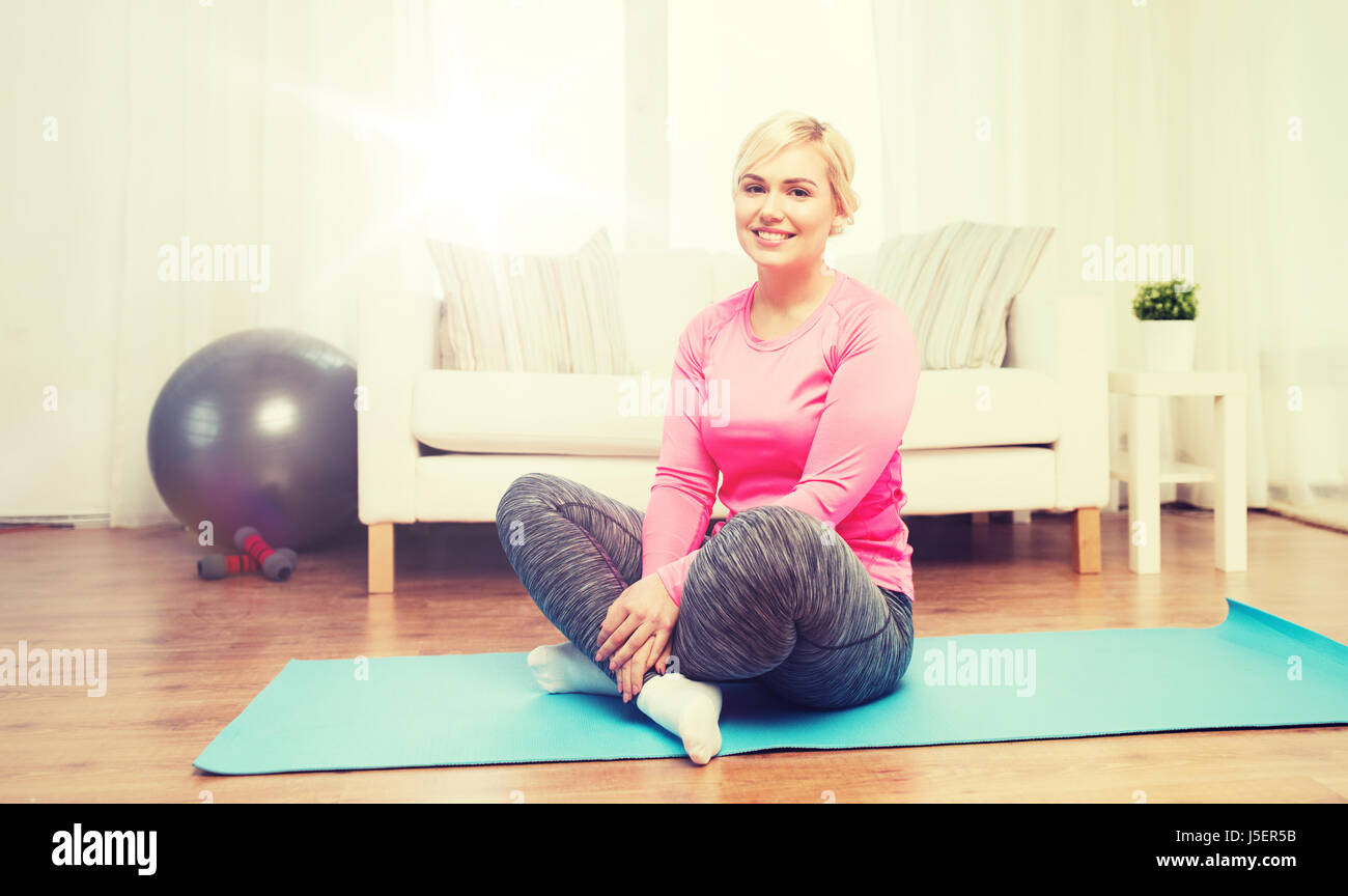 happy woman sitting on mat at home Stock Photo - Alamy