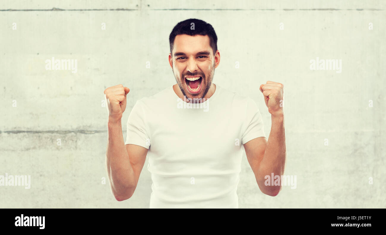 young man celebrating victory over gray Stock Photo - Alamy