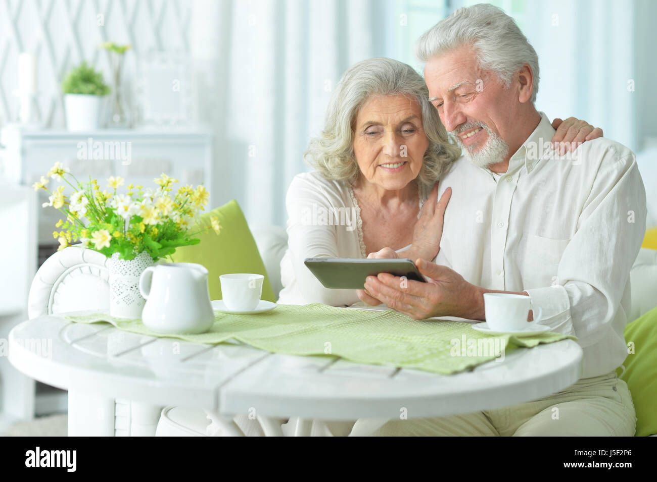 Happy elderly couple using a tablet computer Stock Photo - Alamy