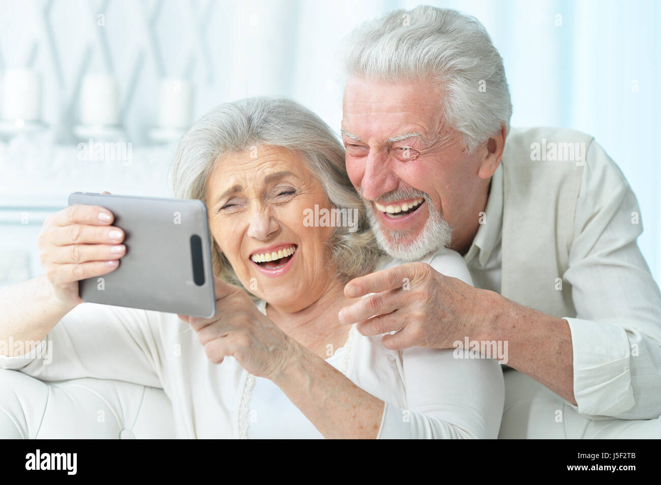 Happy elderly couple with a tablet computer Stock Photo - Alamy